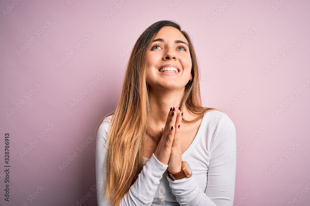 Young beautiful blonde woman with blue eyes wearing white t-shirt over ...