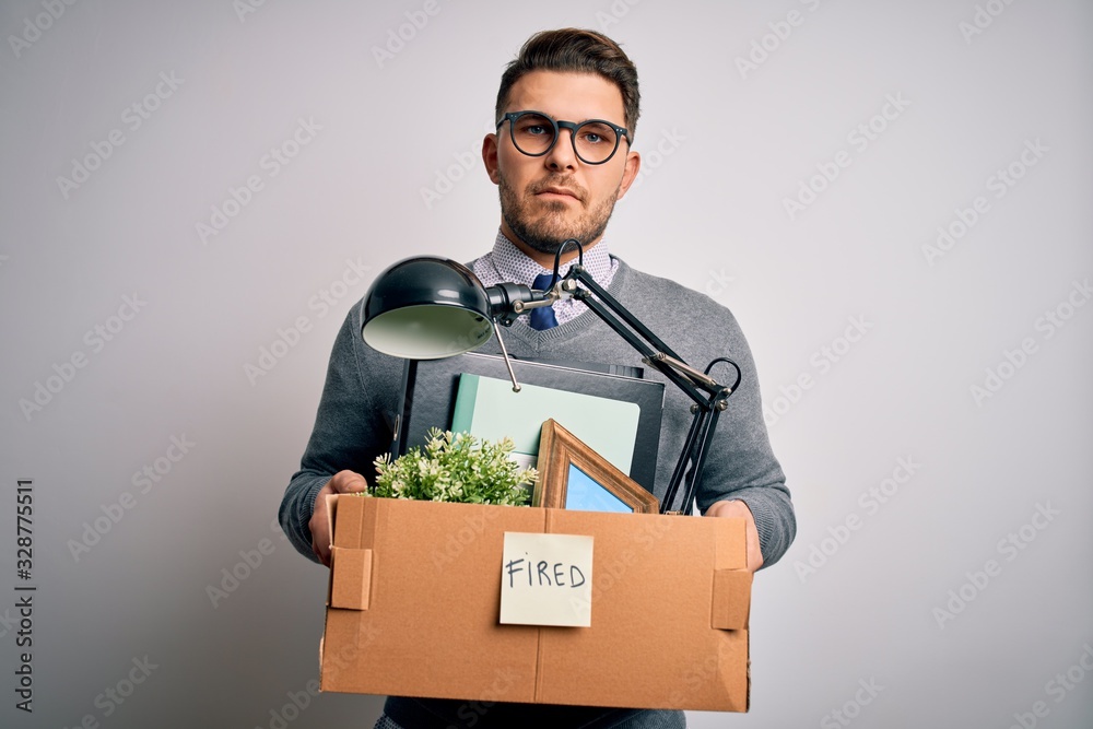 Young business man with blue eyes holding box from the office beeing ...