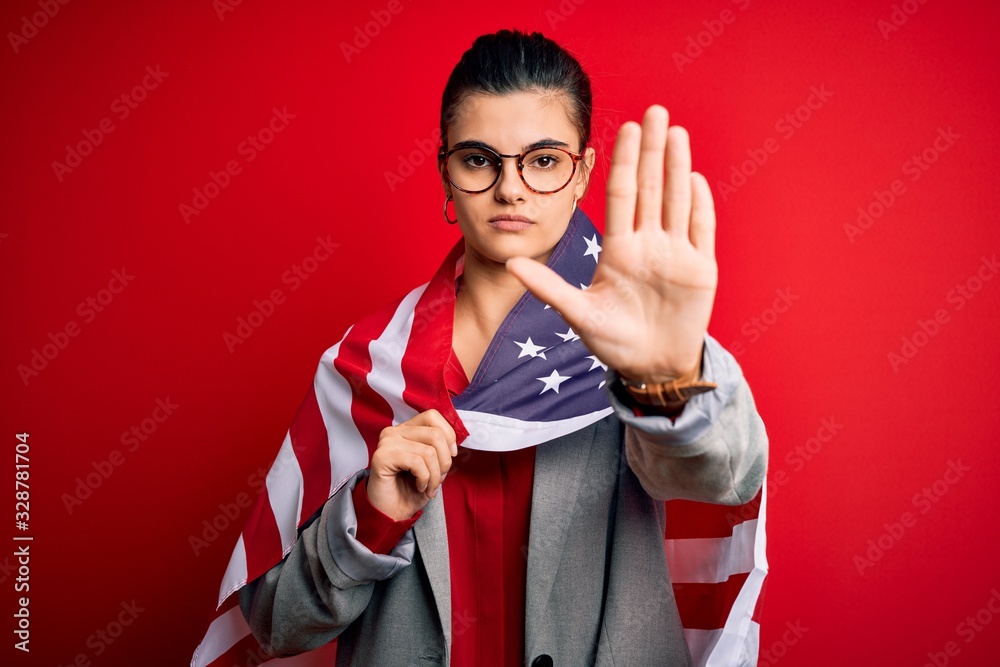 Young beautiful brunette patriotic woman wearing usa flag celebrating ...