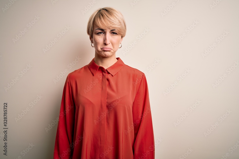 Young beautiful business blonde woman with short hair standing over ...
