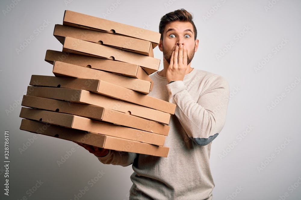 Young blond man with beard and blue eyes holding cardboards of pizza ...