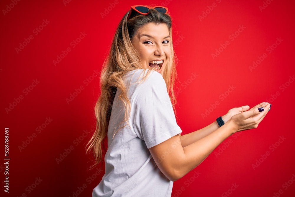 Young beautiful blonde lifeguard woman wearing t-shirt with red cross ...