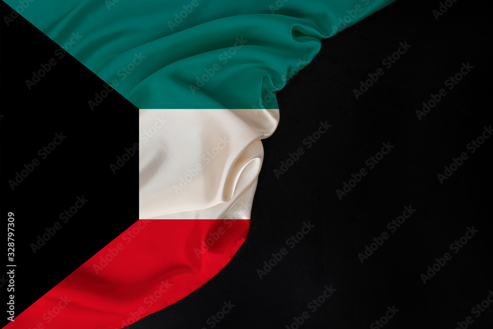 Kuwait state silk national flag folded in soft folds on black blank ...