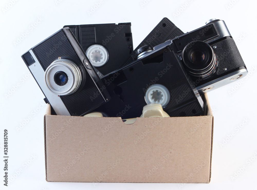 Cardboard box with video cassettes and retro film camera on a white ...
