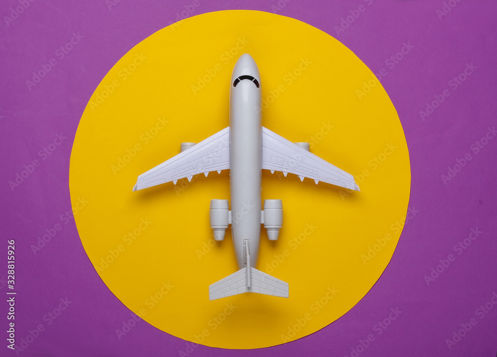 Toy model of plane on a purple background with yellow circle. The ...