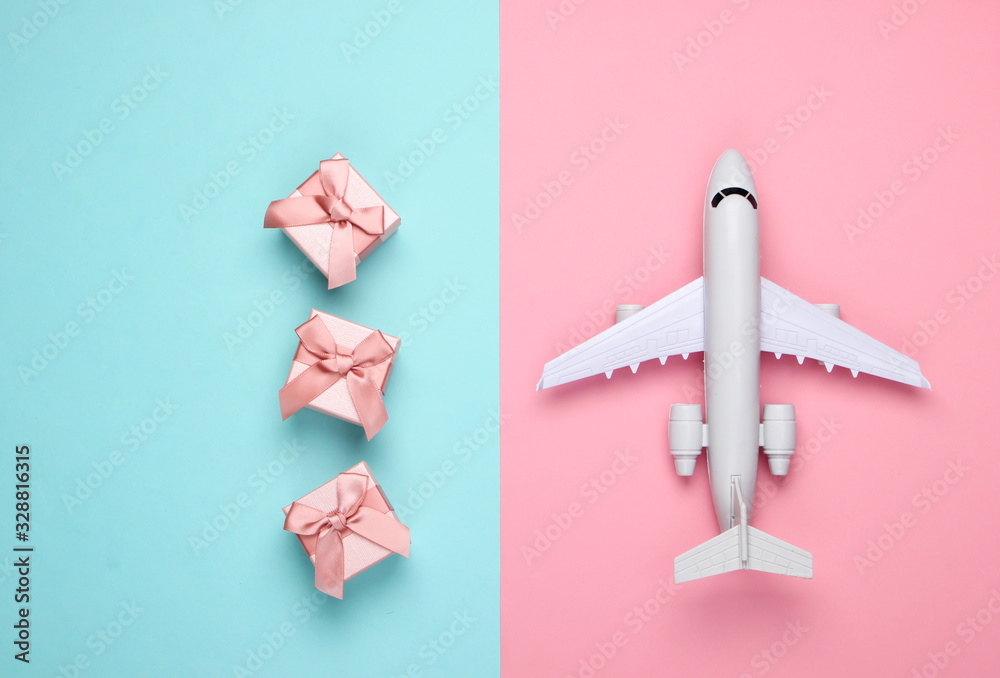 Air delivery. Plane figurine and gift boxes on pink blue pastel ...