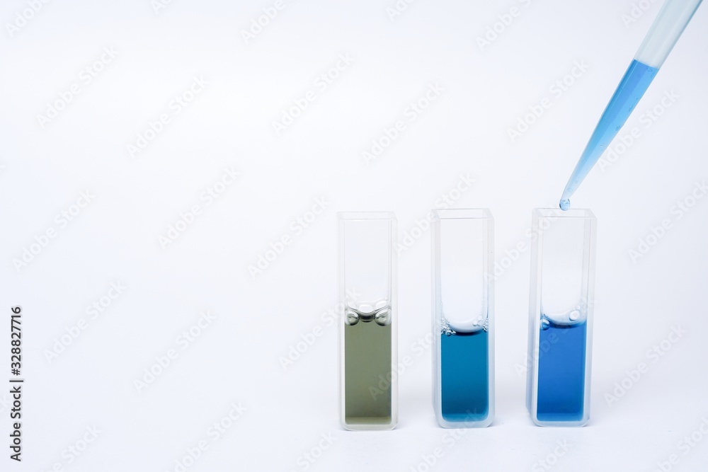 Adding blue reagent into the cuvette on isolated white background ...