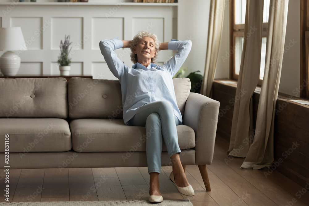 Relaxed mature 60s grandmother sit on couch in living room sleep ...