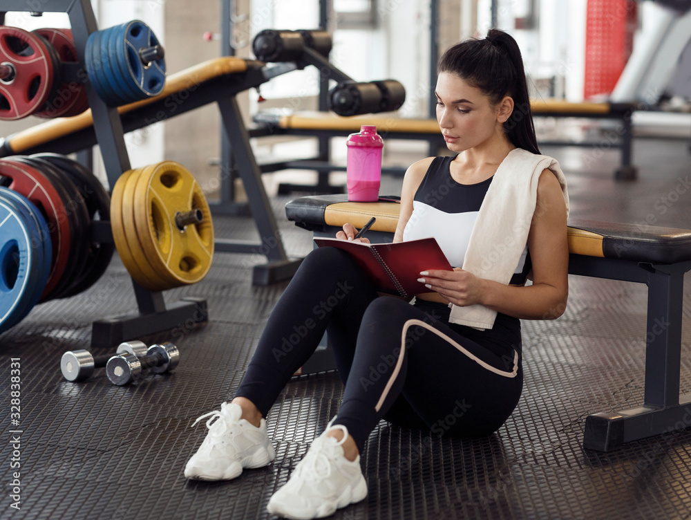 Beautiful woman making her training plan in sports club Stock Photo ...