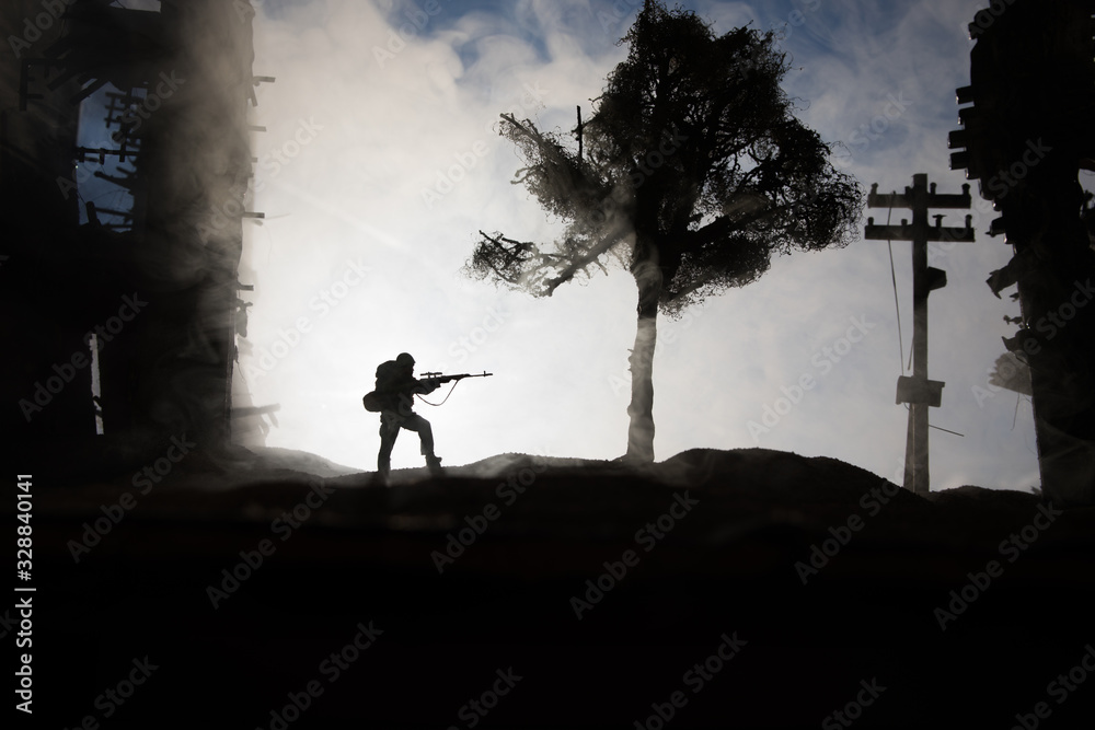 Army sniper with large caliber rifle standing in the fire and smoke ...