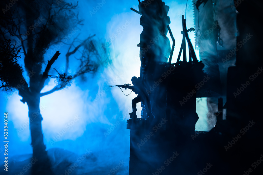 Army sniper with large caliber rifle standing in the fire and smoke ...