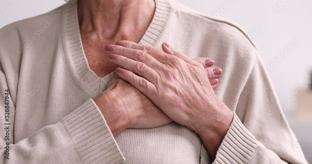 Grateful pleased senior elder woman holding hands on chest gesture ...