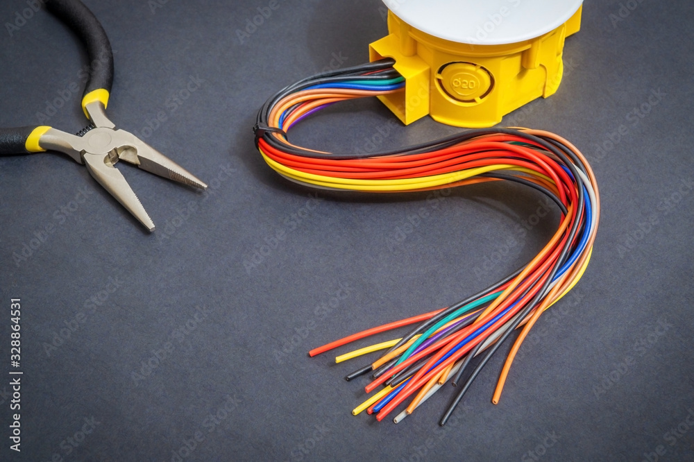 Electrical junction box with wires and tool on black background usually ...