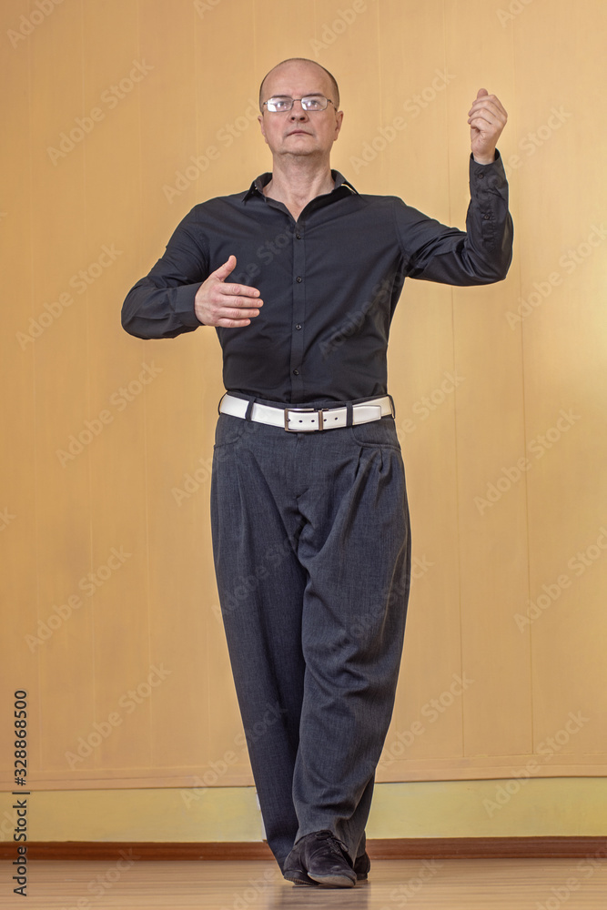 Sensual flexible men in the studio are training and dancing tango in a ...