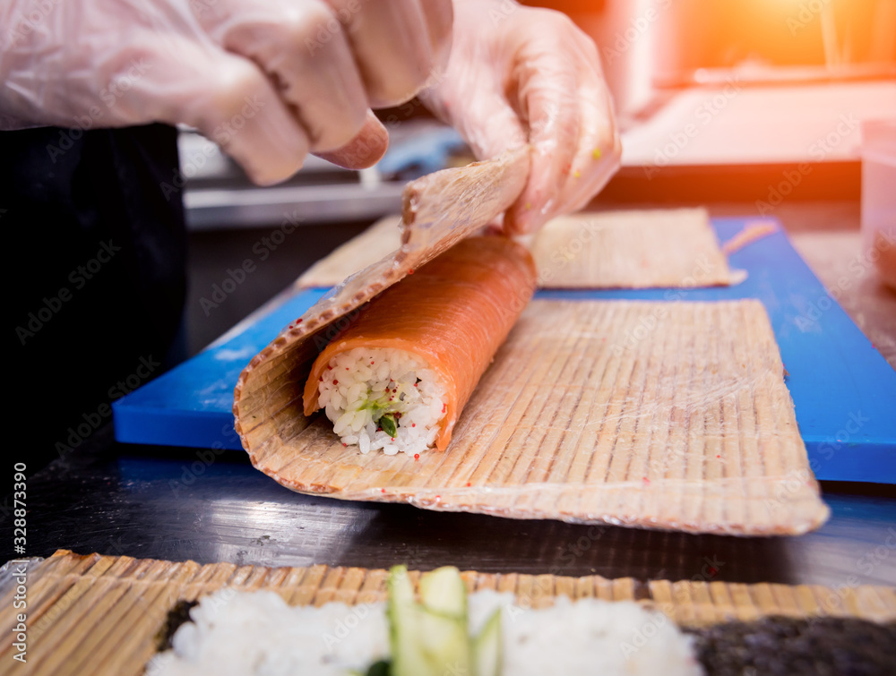 Process of making sushi and rolls at restaurant kitchen. Chefs hands ...