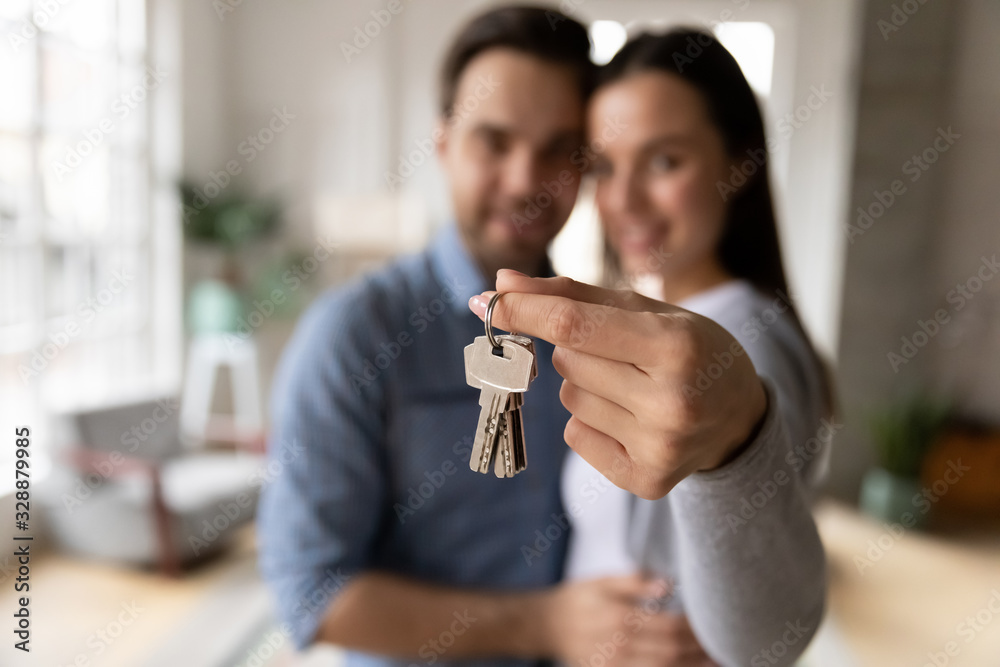 Focus on keys, held by excited young spouses homeowners. Happy married ...