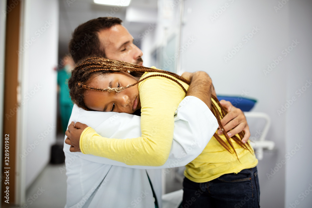 Doctor having conversation with sad little girl at the hospital. Doctor ...