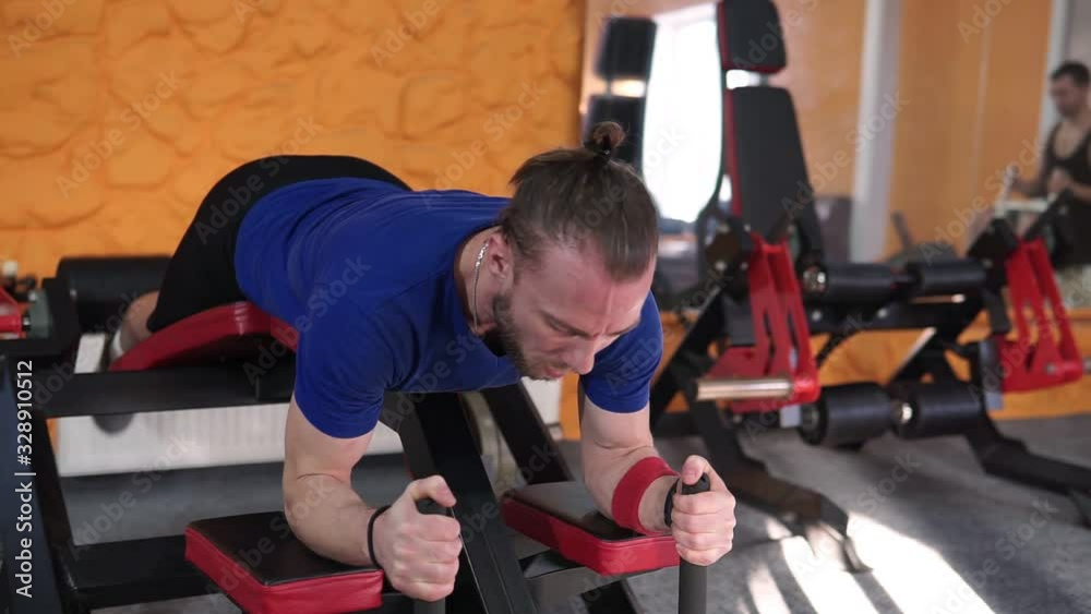 Guy bodybuilder in the gym, working with a bar, to be tightened ...