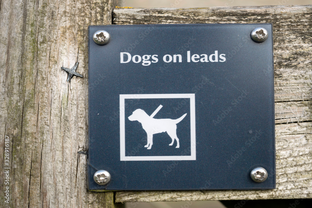 Dogs on leads black sign with symbol and text written in white. foto de ...