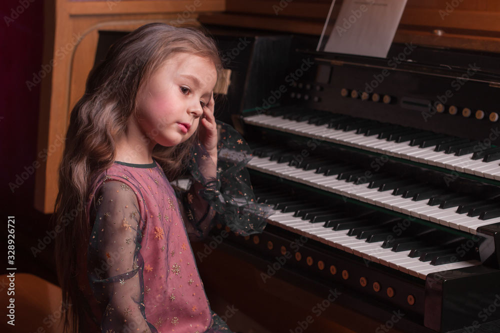 Little girl playing a pipe organ Stock Photo | Adobe Stock