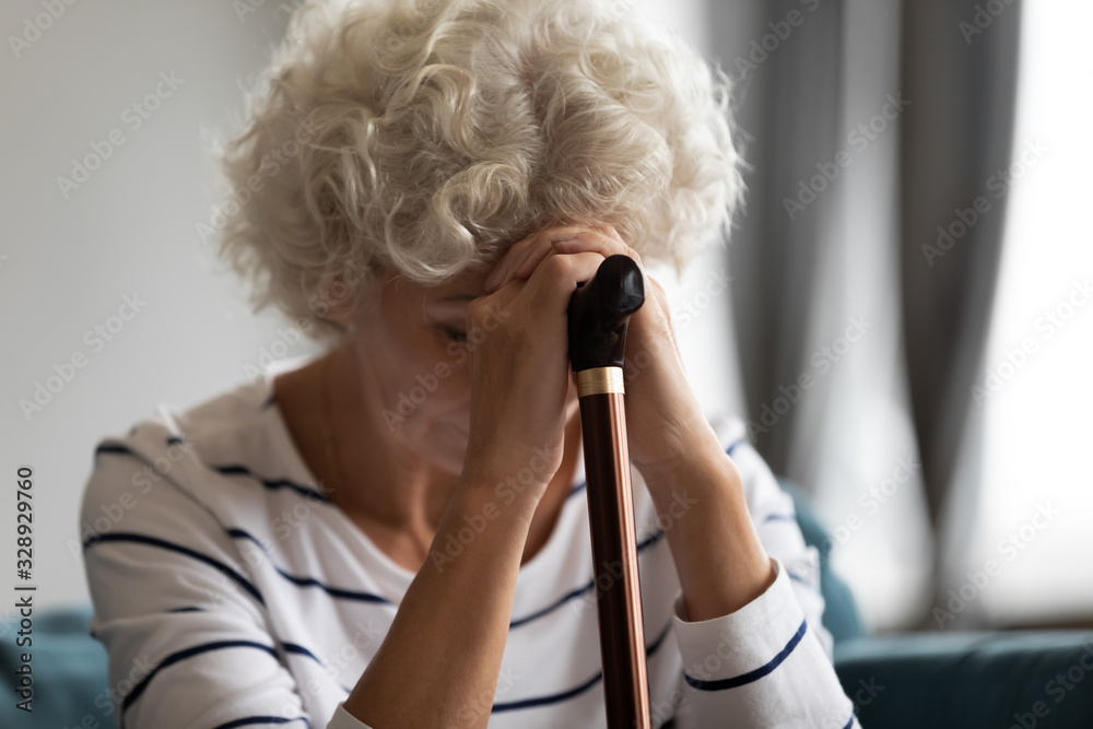 Upset distressed mature 60s grandmother with walking stick feel lonely ...