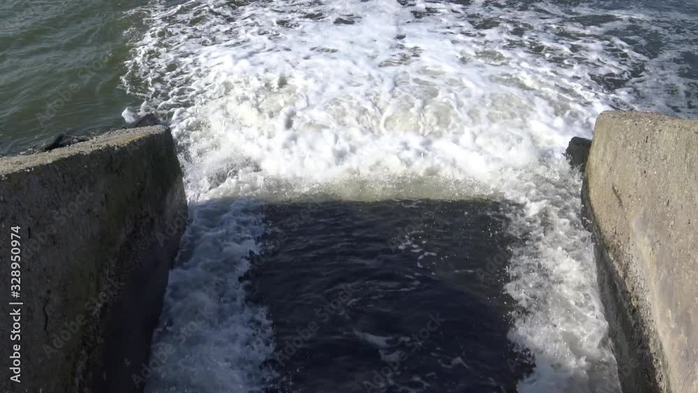 Water pollution. Dirty water from treatment plants flows through a pipe ...