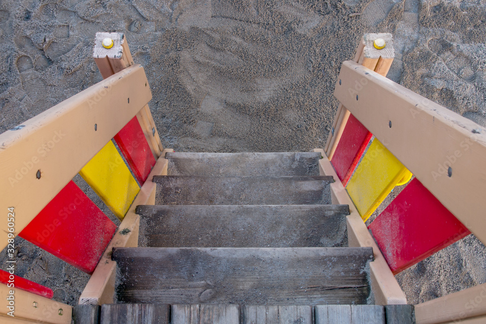 Wooden staircase on playground with plank steps covered with gray sand ...