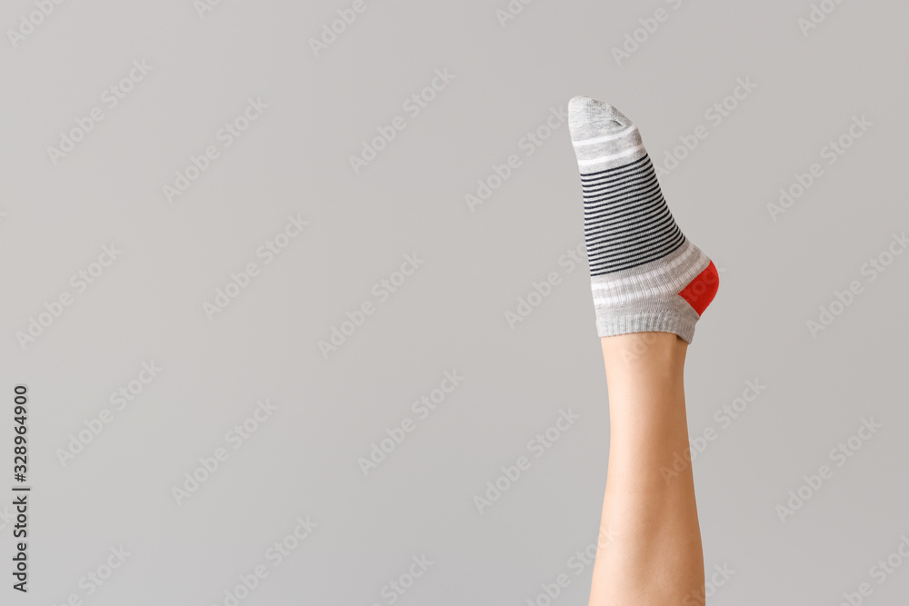 Leg of woman in sock on grey background Stock Photo | Adobe Stock