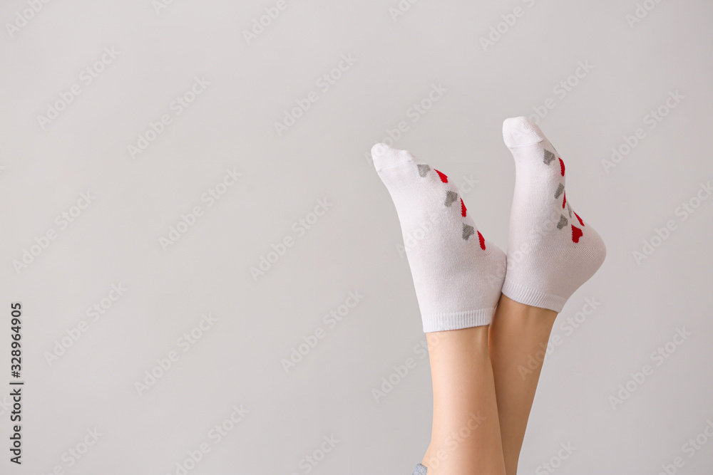 Legs of woman in socks on grey background Stock Photo | Adobe Stock