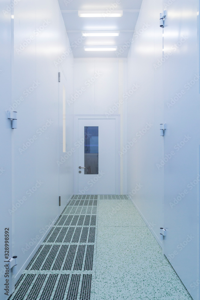 Inside white sterile clean room .Hallway with raised floor and door in ...