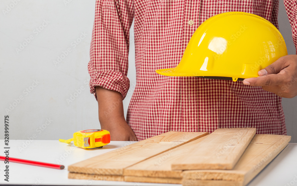 joiner measuring a wooden plank with tape measure yellow on the work ...
