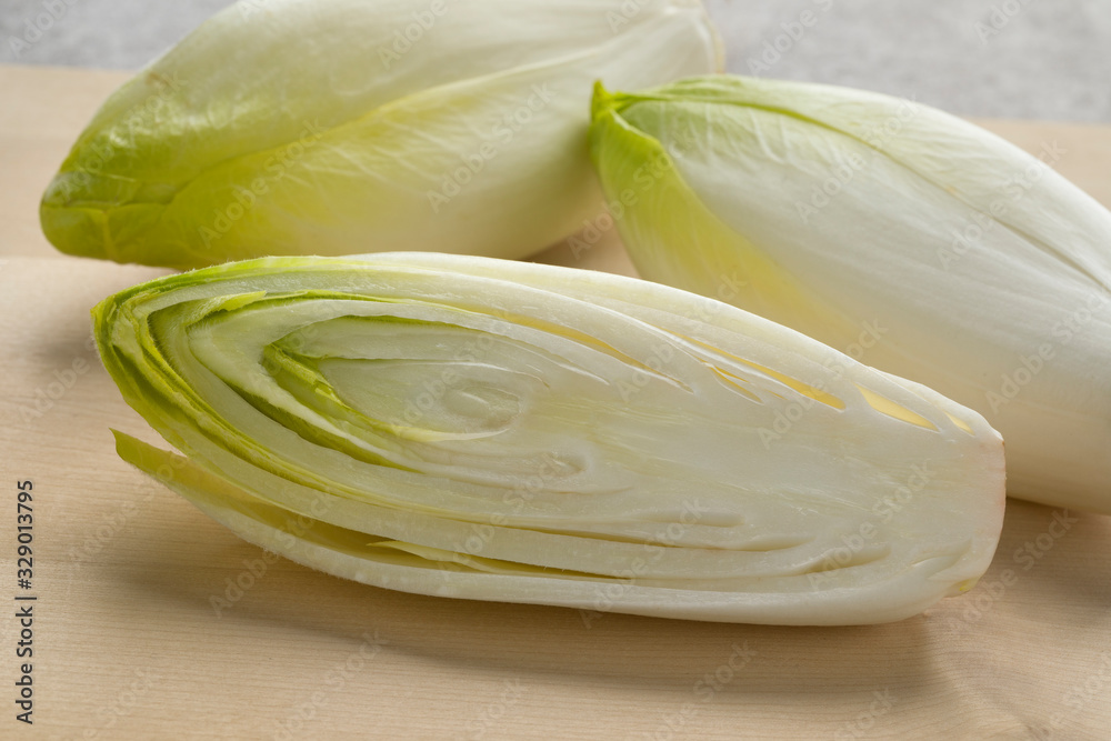 Whole and half fresh raw Belgian endive Stock Photo | Adobe Stock