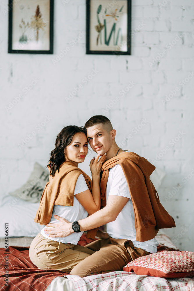 Beautiful couple on the bed. Love story in the interior Studio. Happy ...