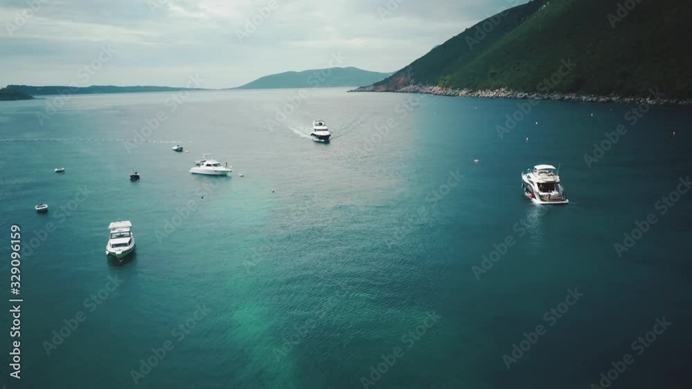 Yachts are sailing on the sea on the greenery mount island background ...