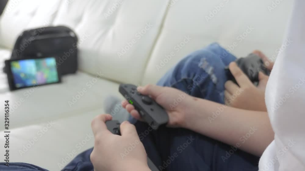 children play console in gamepads teamwork. kids a boy and a girl are ...