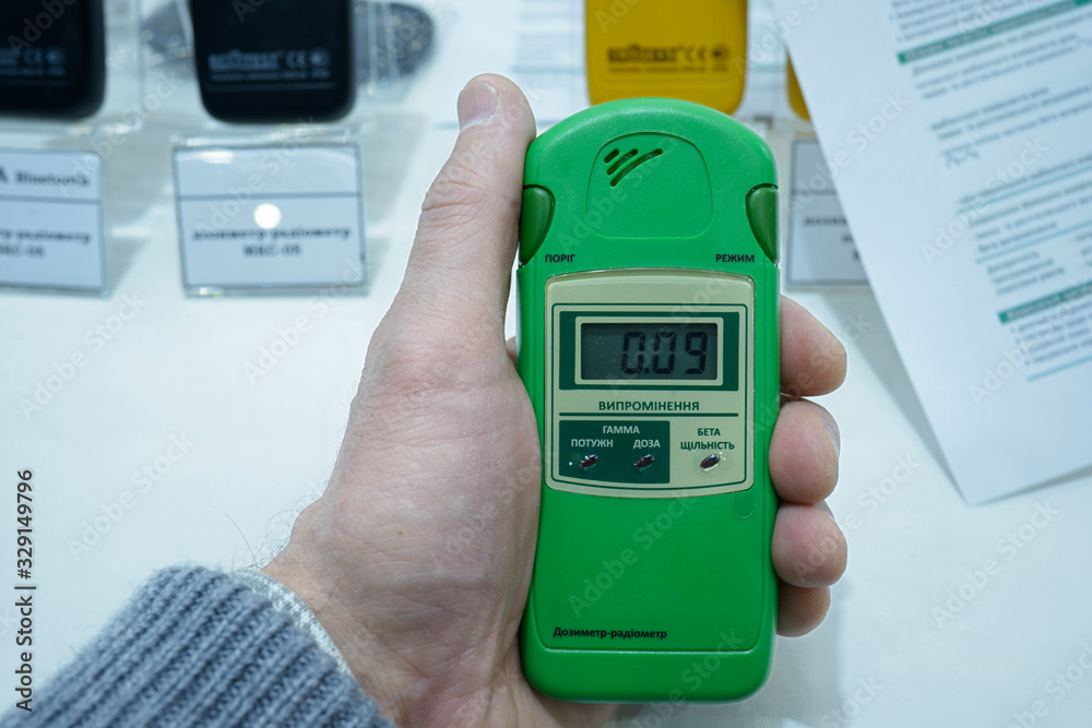 Customer hand holding personal dosimeter-radiometers for measuring ...