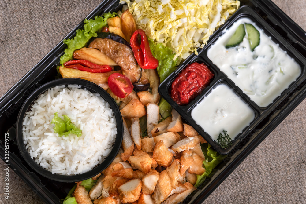 Traditional doner kebab in a black plastic container, sour cream, white ...