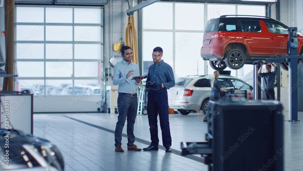 Manager Checks Diagnostics Results on a Tablet Computer and Explains a ...