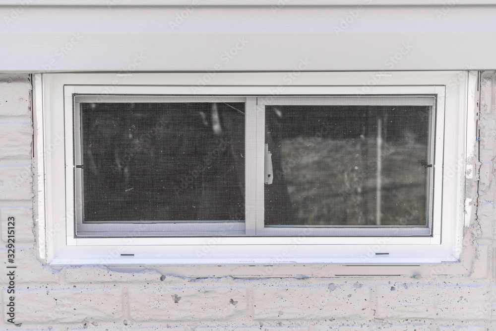 Basement sliding window with thick white frame on a newly constructed ...