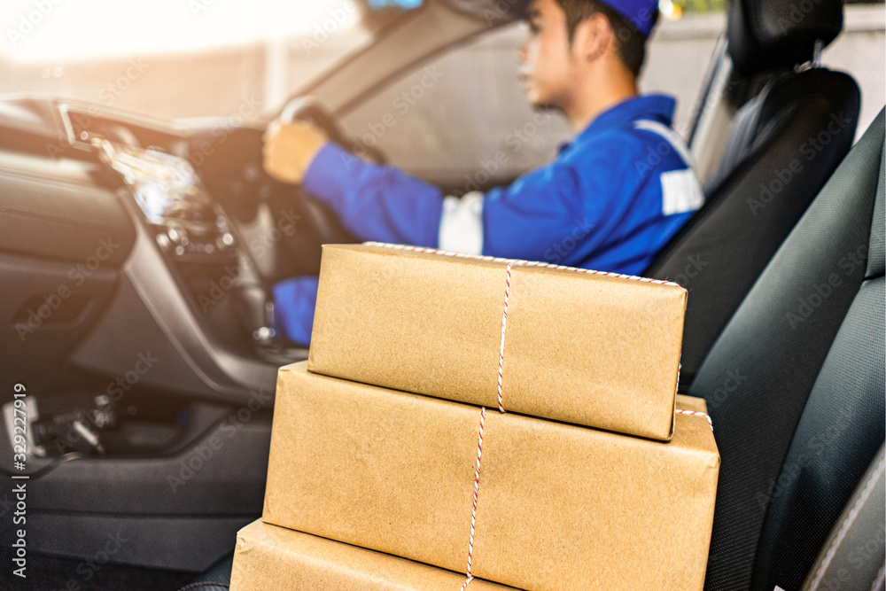 close up asian post delivery man holding boxes of brown parcel with ...