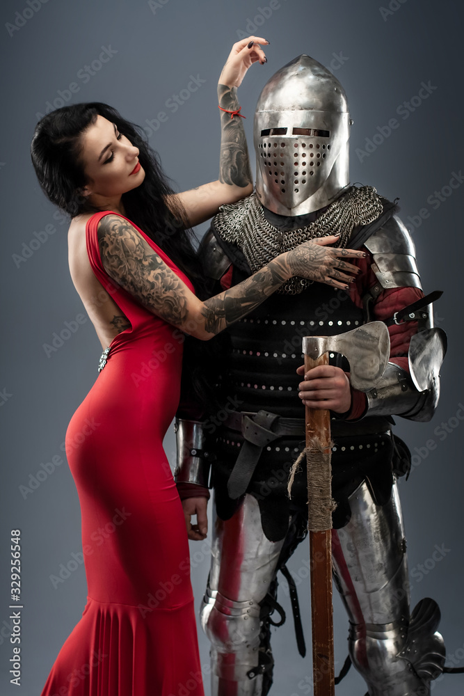 Beautiful girl in a red dress and knight in armor Stock Photo | Adobe Stock
