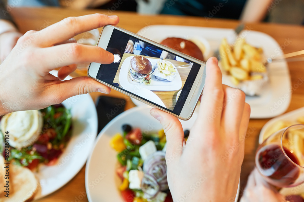 Essen fotografieren im Restaurant mit Handy Stock Photo | Adobe Stock