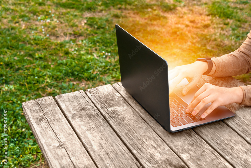 Human Female Hands working on PC grey Laptop on wood table in green ...