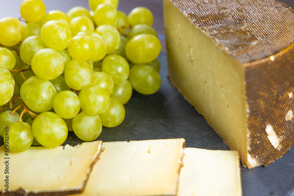 Still life of fresh cheeses of different flavors with fresh grapes ...