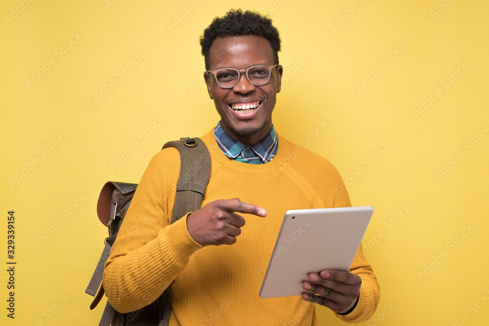 Happy african american college student holding tablet on isolated ...