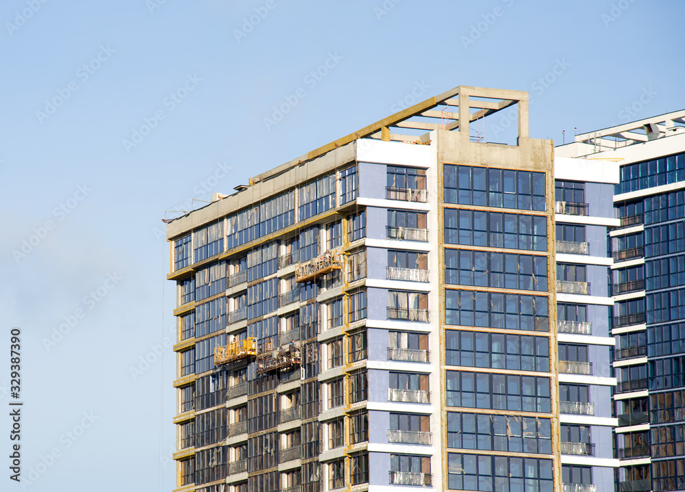Suspended cradle on the facade of the skyscraper. Mobile scaffolding ...