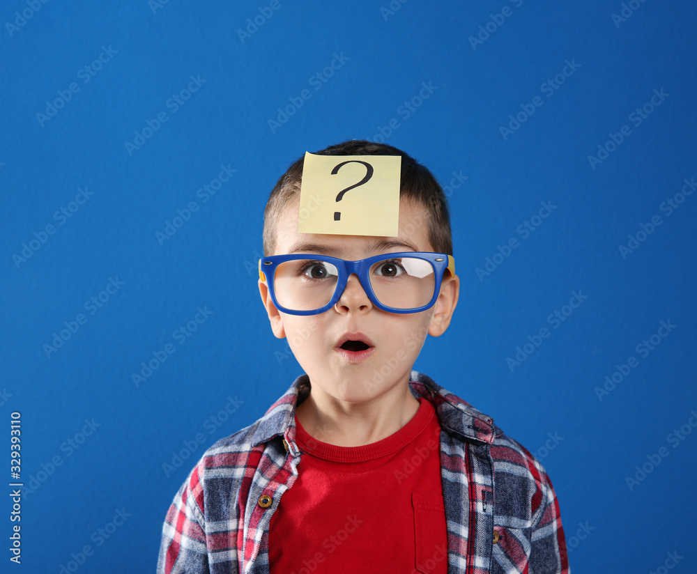 Emotional little boy with question mark on blue background Stock Photo ...