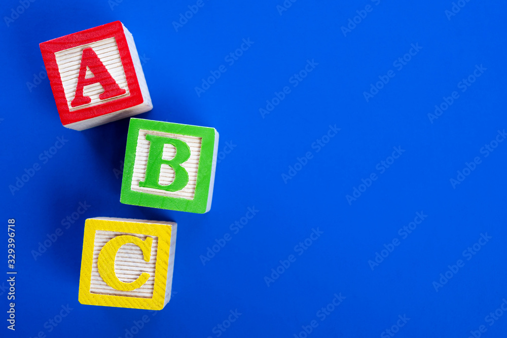 Wooden ABC blocks on blue background Stock Photo | Adobe Stock