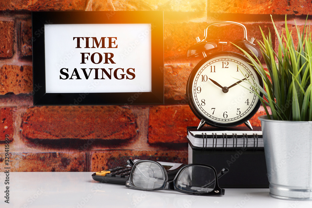 TIME FOR SAVINGS text with alarm clock, books and vase on brick ...