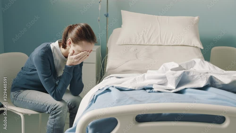 Sad woman crying next to an empty hospital bed Stock 비디오 | Adobe Stock